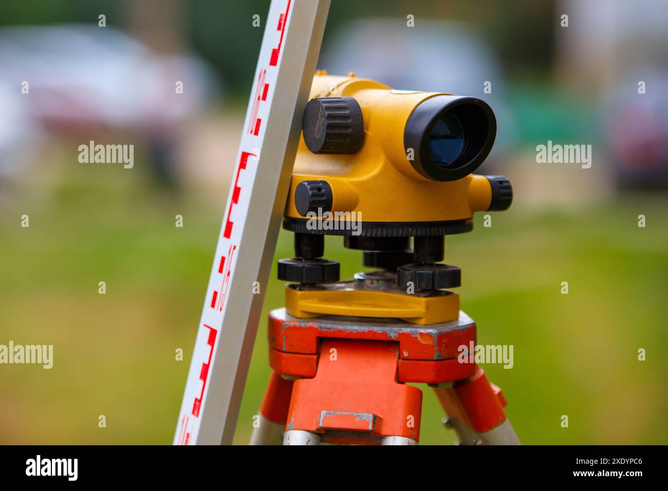 Close-up view of cheap geodesy level device with tower ruler outdoors ...