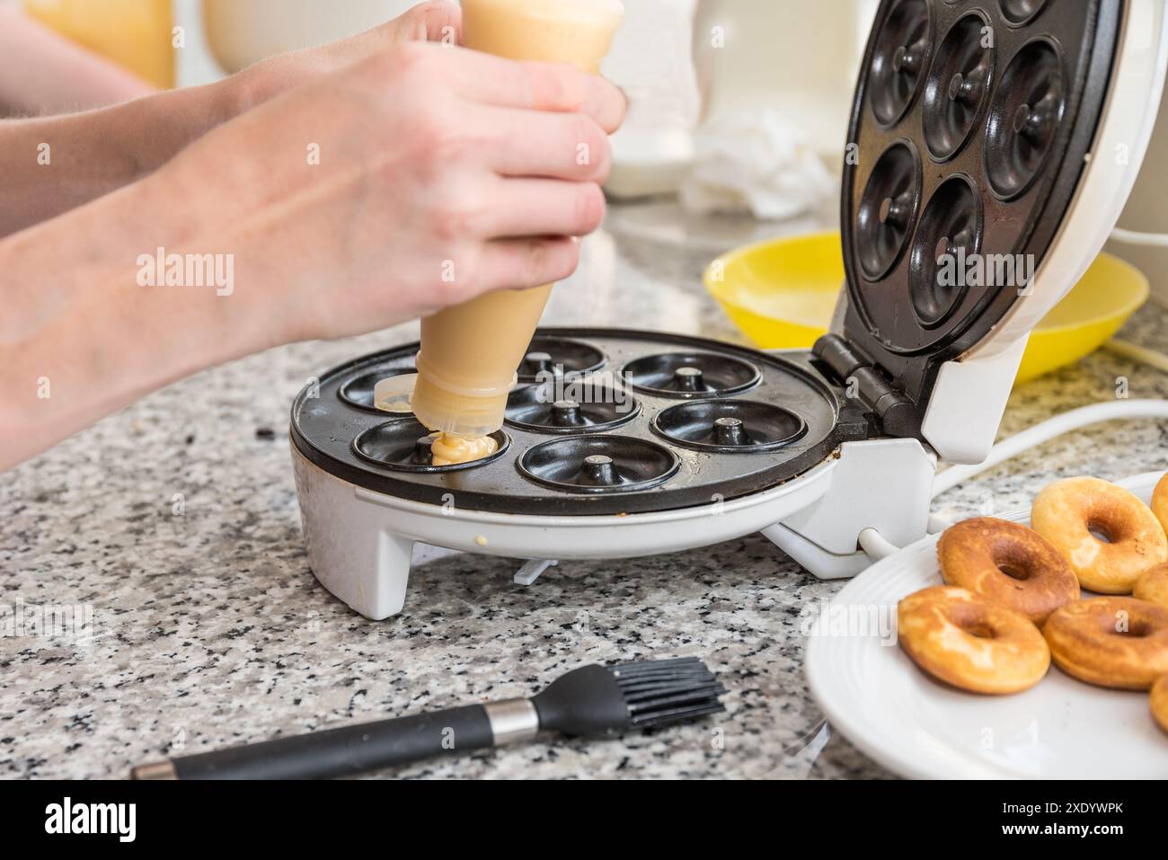Prepare mini donuts yourself with a donut machine - dessert Stock Photo ...