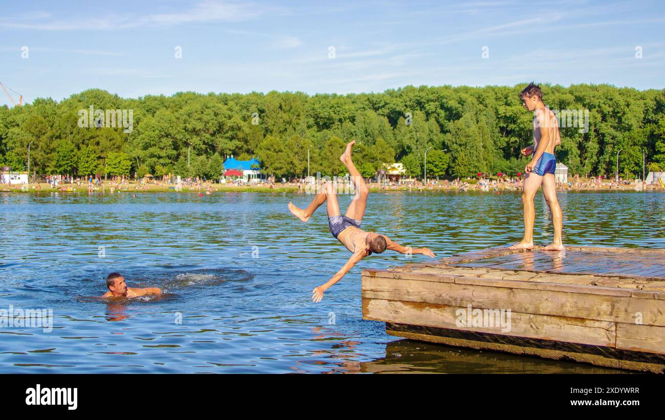 Summer vacation on city beach. Men do somersaults Stock Photo - Alamy