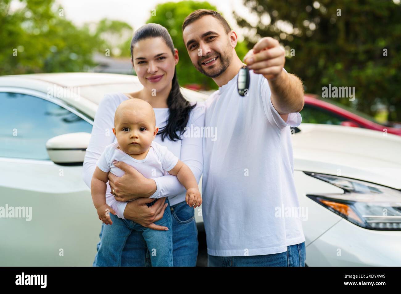 Young family with little child show key of their new car Stock Photo ...