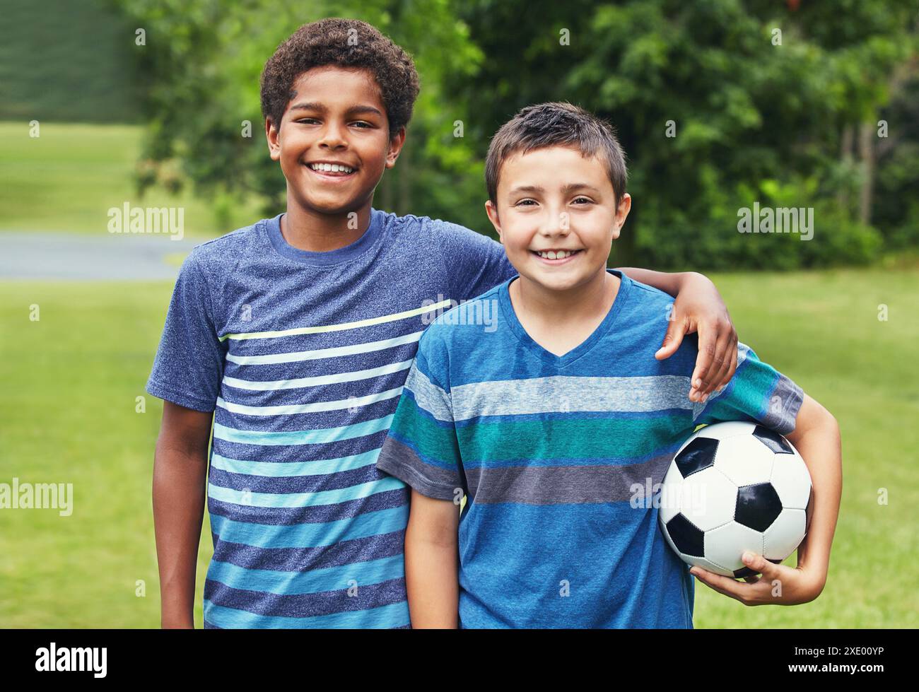Boys, hug and portrait of children with soccer ball in park for ...
