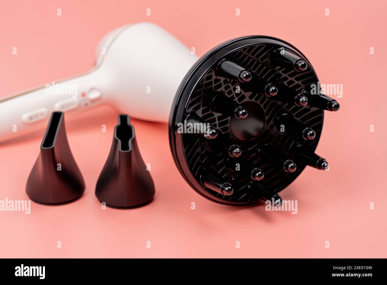 Hair dryer for drying hair on a pink background. The buttons are ...
