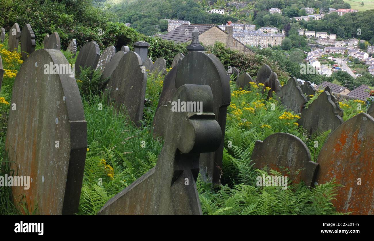 Gravestones overgrown with weeds overlooking the town of hebden bridge ...