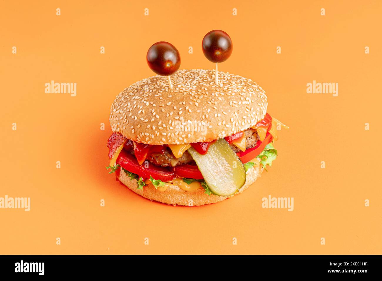 Funny Monster Burger on the orange background Stock Photo - Alamy