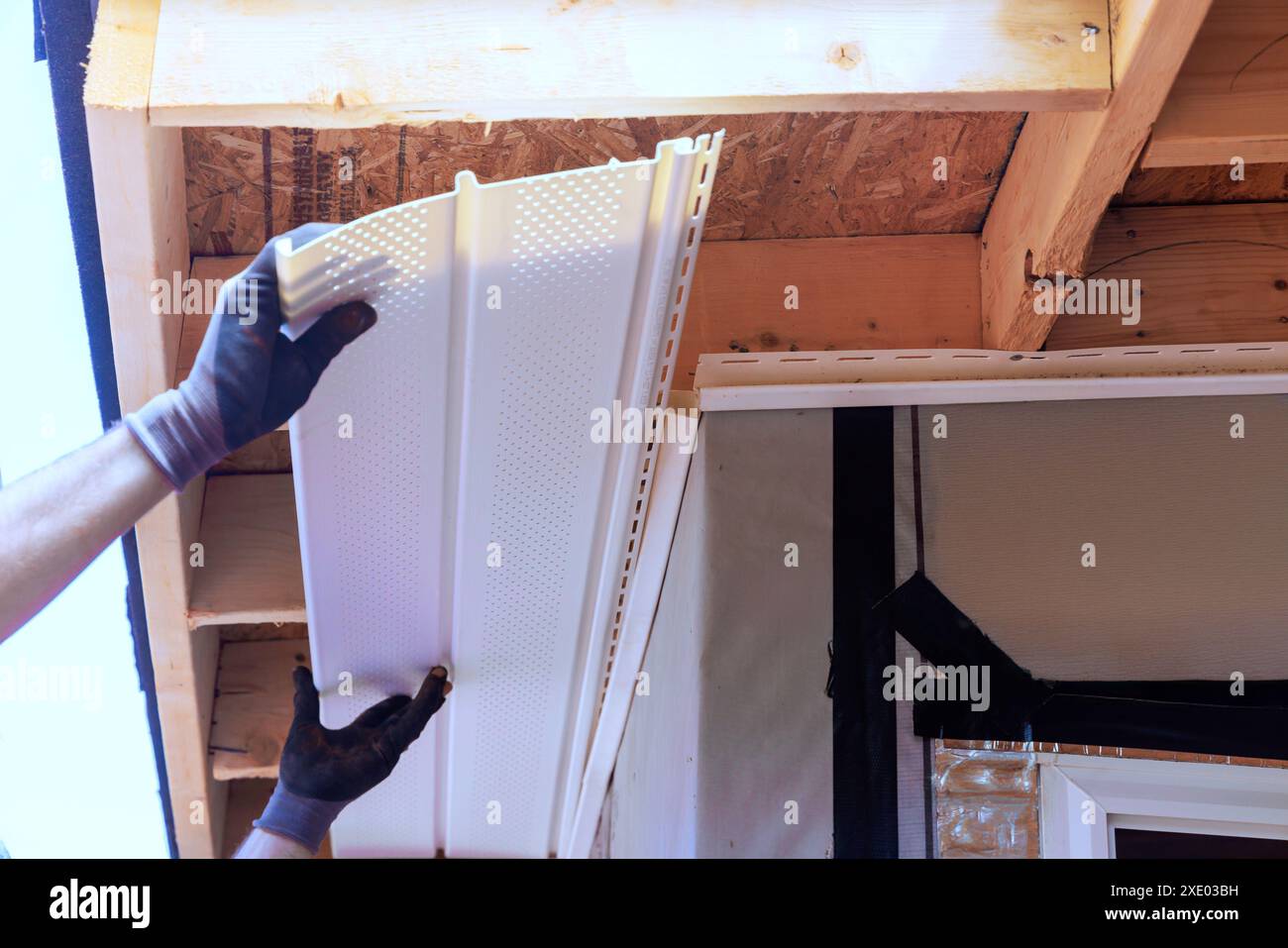 Nailing upvc soffit boards to roof rafters on ceiling house Stock Photo ...