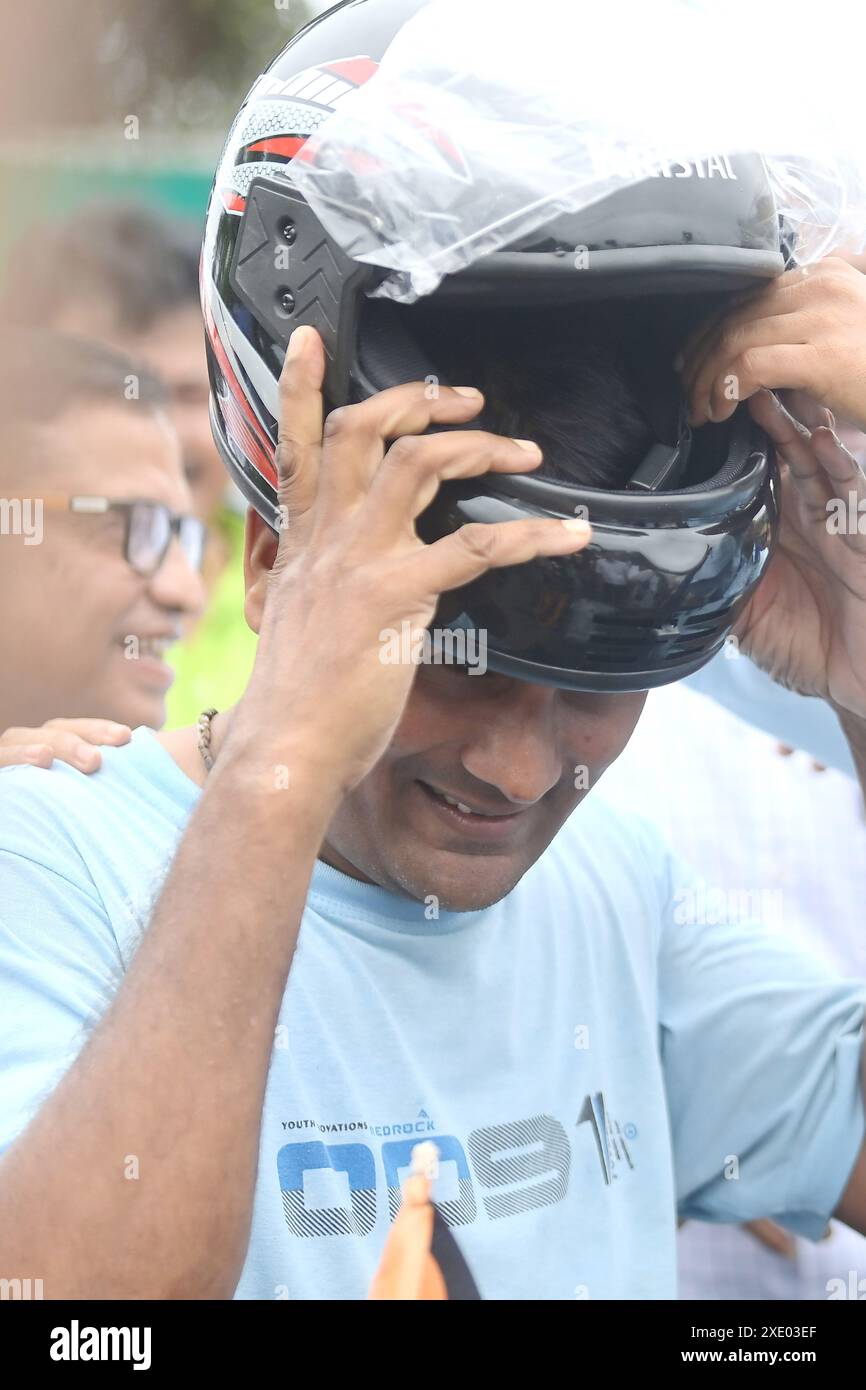 A traffic official puts a helmet on a motorist during a helmet ...
