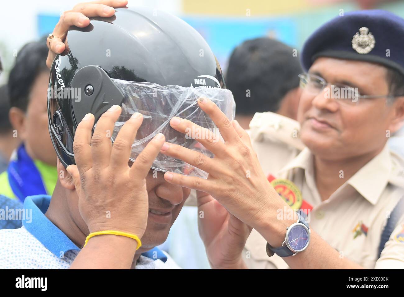 A traffic official puts a helmet on a motorist during a helmet ...