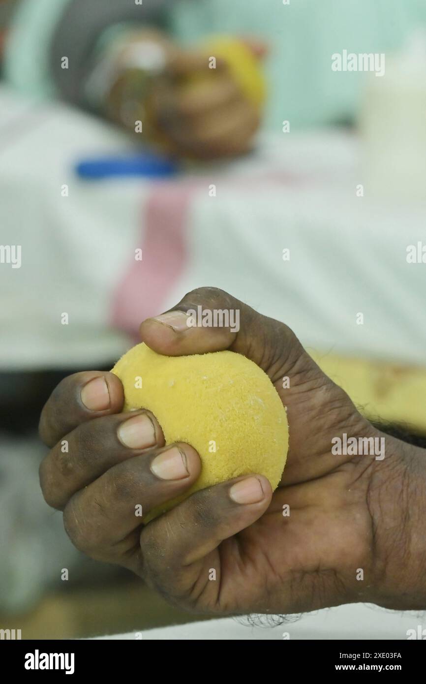 A man squeezes a sponge ball as he donates blood on World Blood Donor ...
