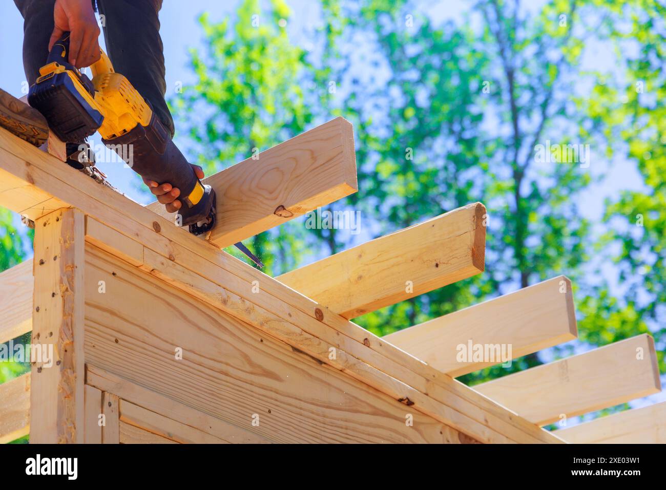 Contractor builder uses cordless reciprocating saw to cut beam during ...