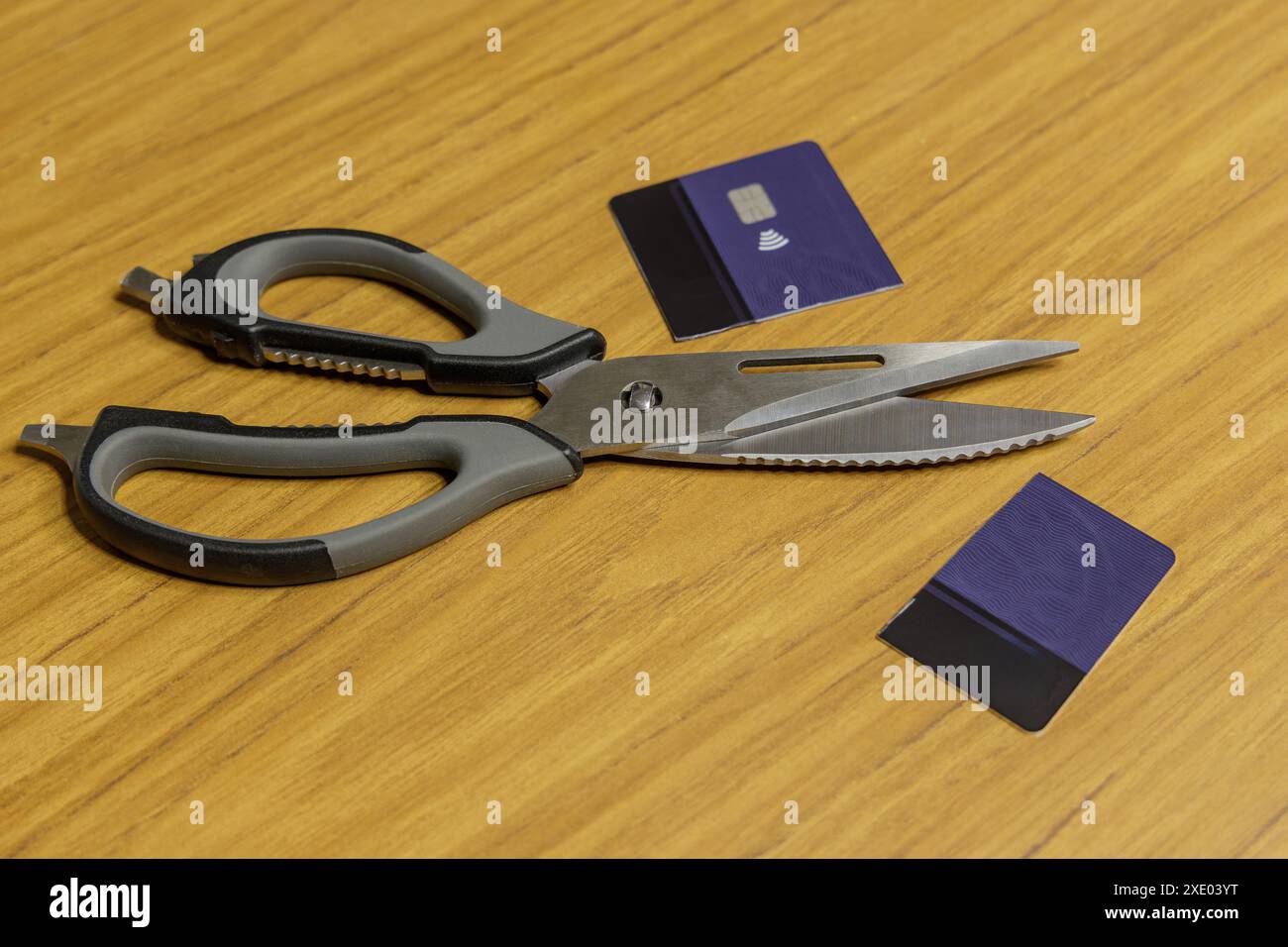 Cut credit card next to scissors on a table Stock Photo - Alamy