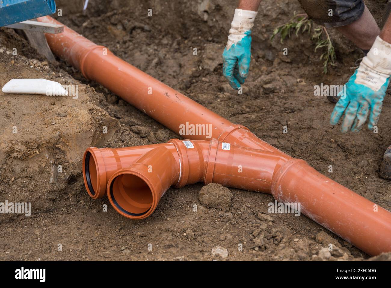 Construction site with construction workers laying PVC sewer pipe ...