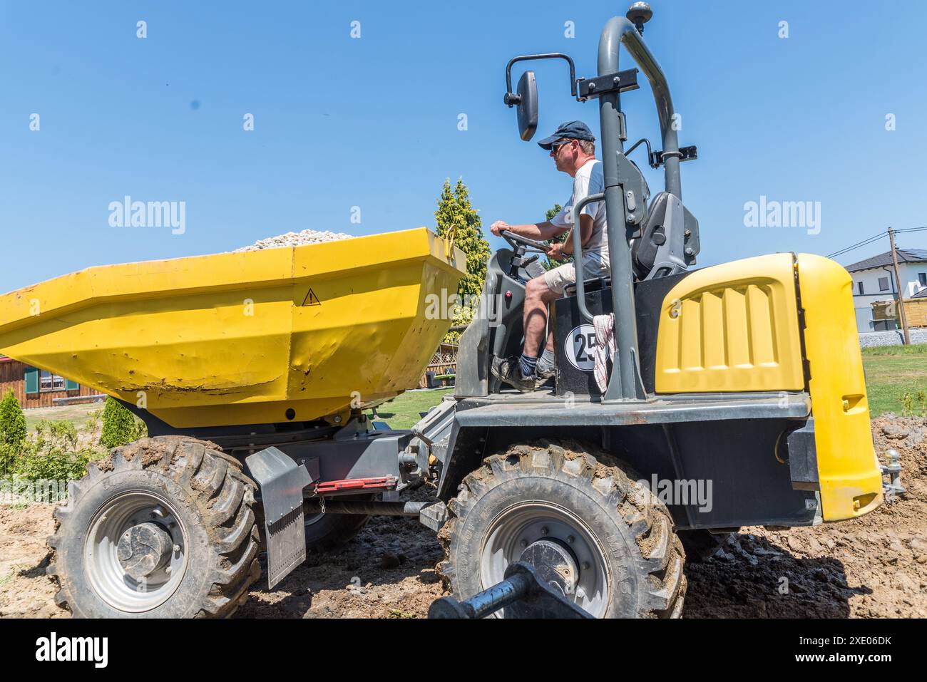 Construction worker drives on the construction site with dumper ...