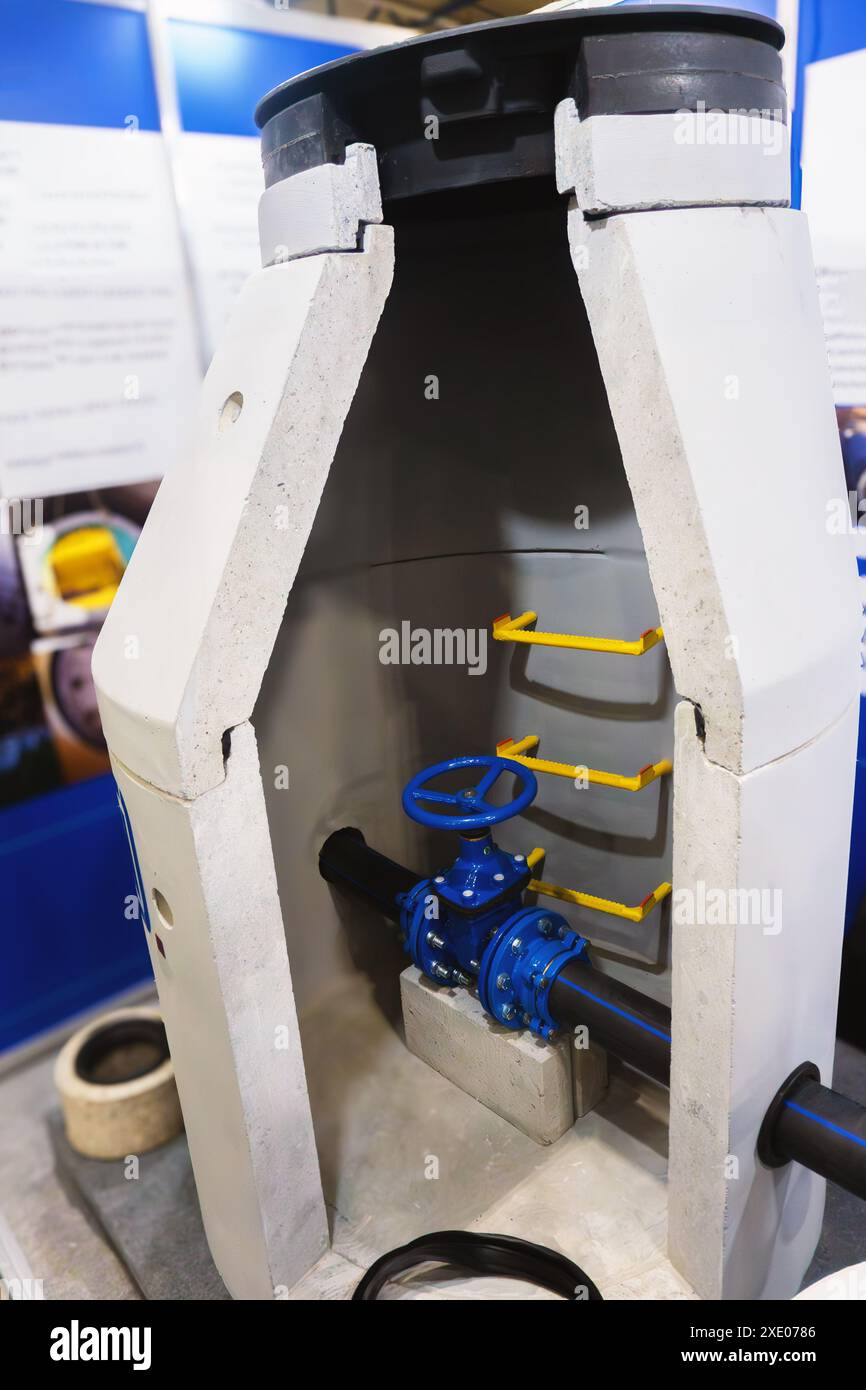 Concrete well with a hatch and a blue industrial valve for water ...