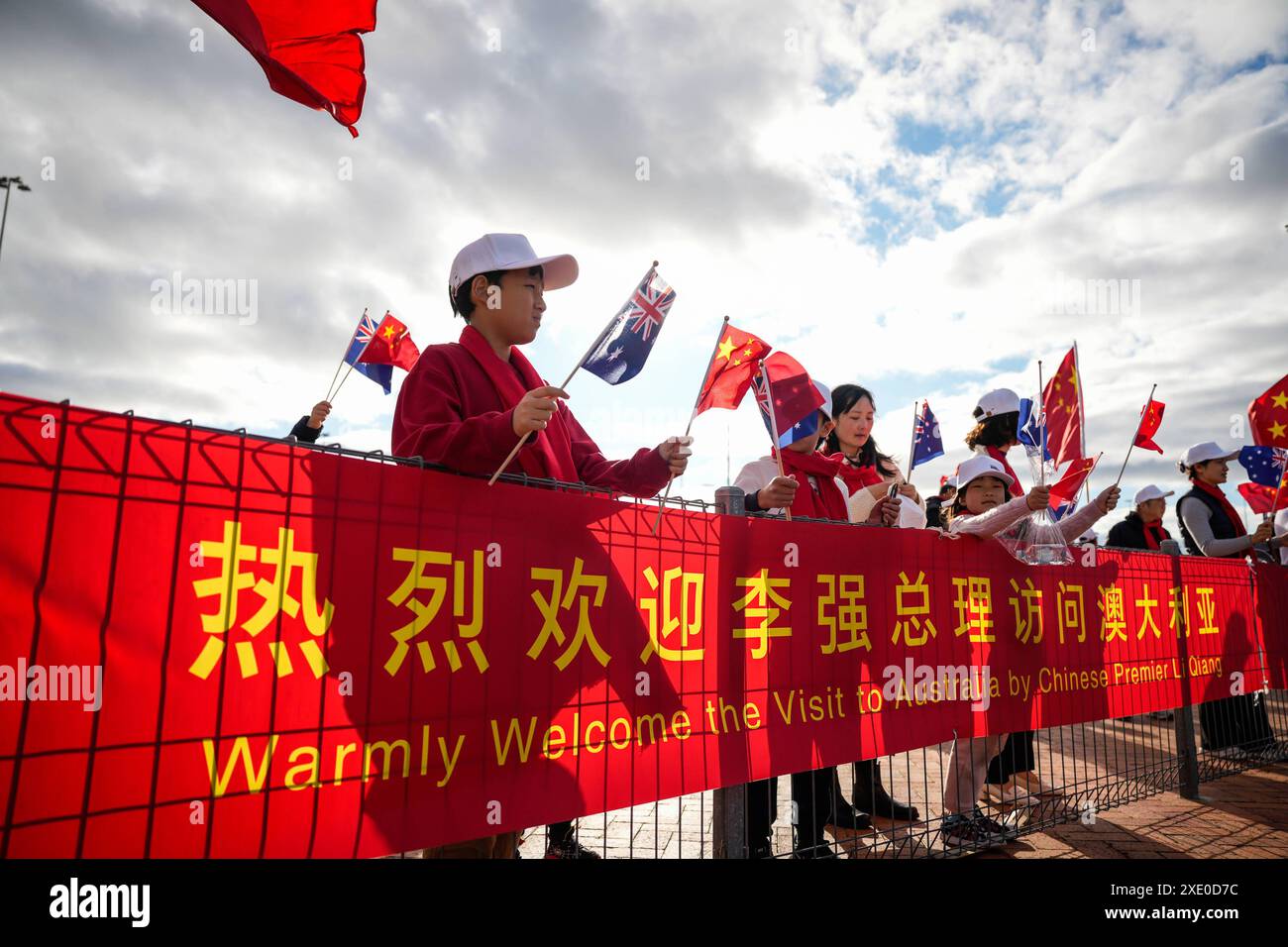 People wave Chinese national flags and Australian flags as they await ...