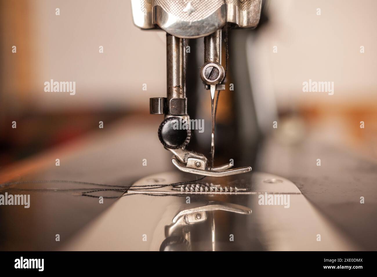 Old sewing machine stands on the table at home ready to work and sew ...
