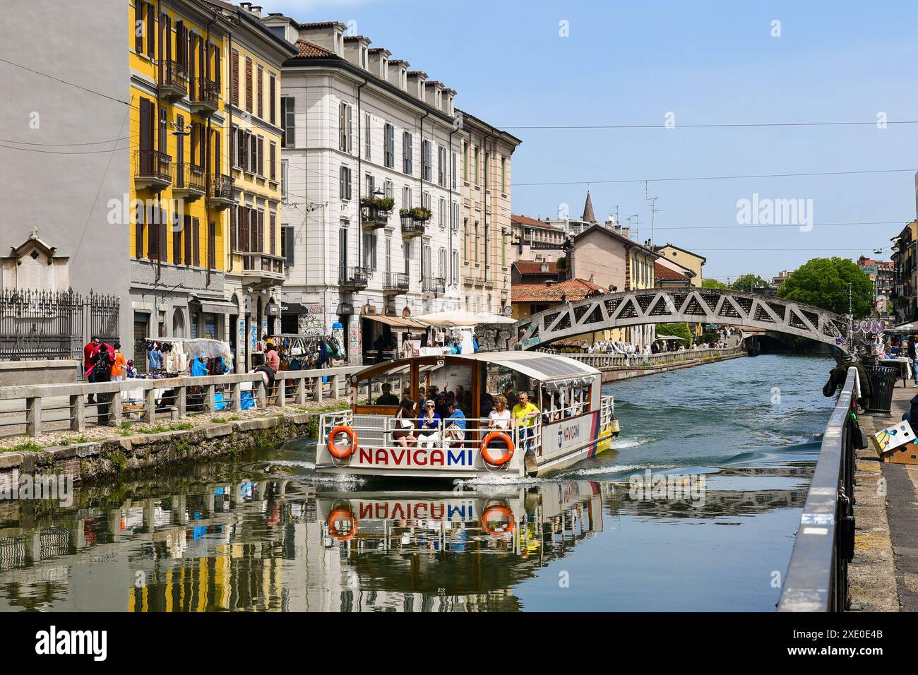 A tour boat full of people on the Naviglio Grande waterway with the ...