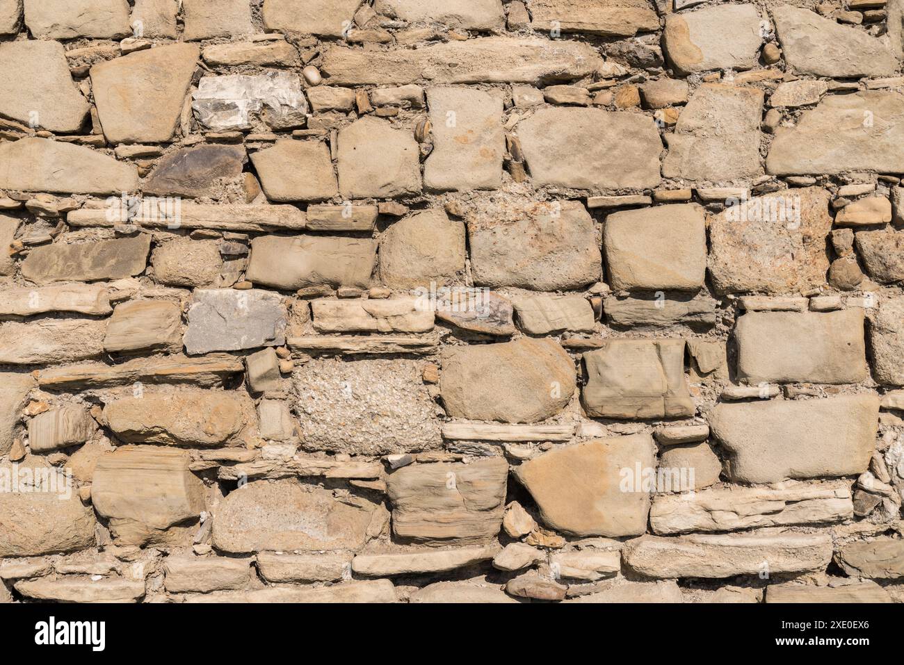 Brown natural and irregular stone wall and background Stock Photo - Alamy