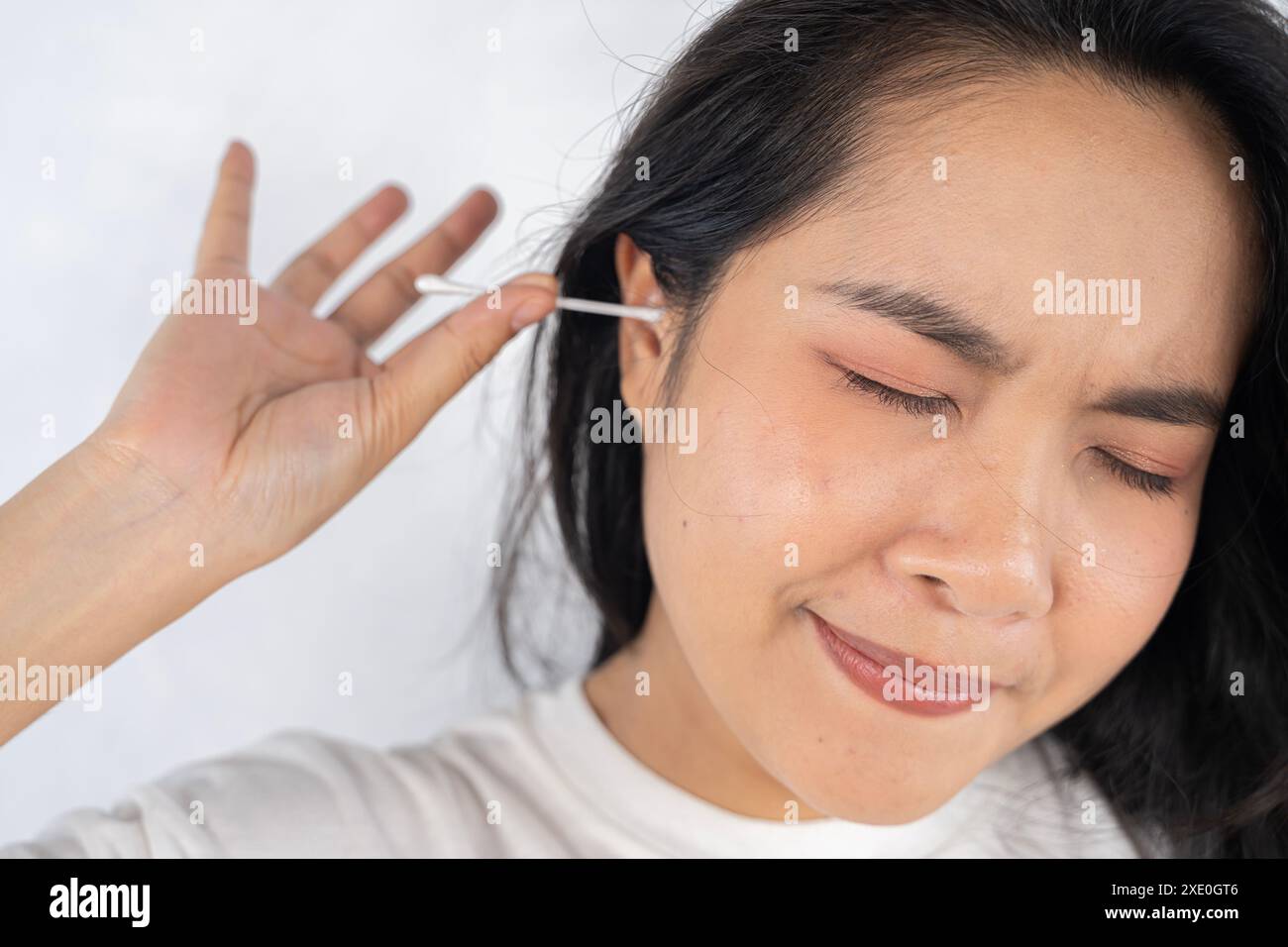 Close up young woman cleaning ears, using cotton bud after shower ...