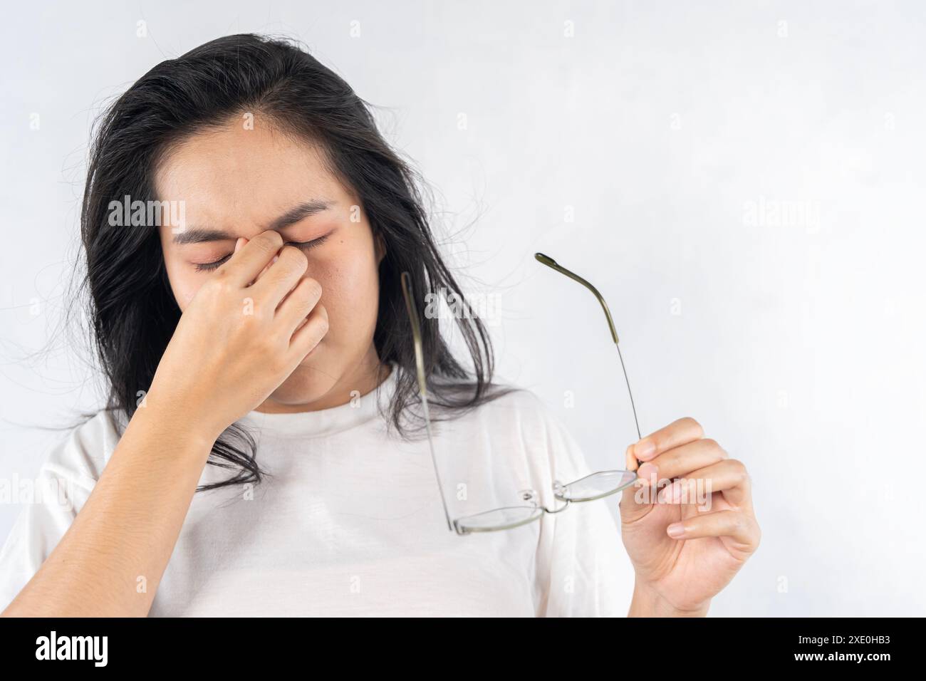 Young woman rubs her eyes after using glasses, touching eyelids, face ...
