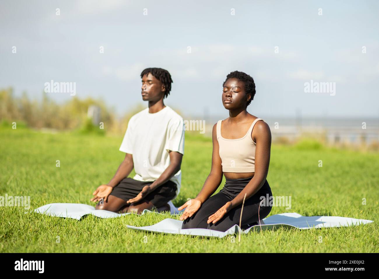 Two people meditating on beach hi-res stock photography and images - Alamy