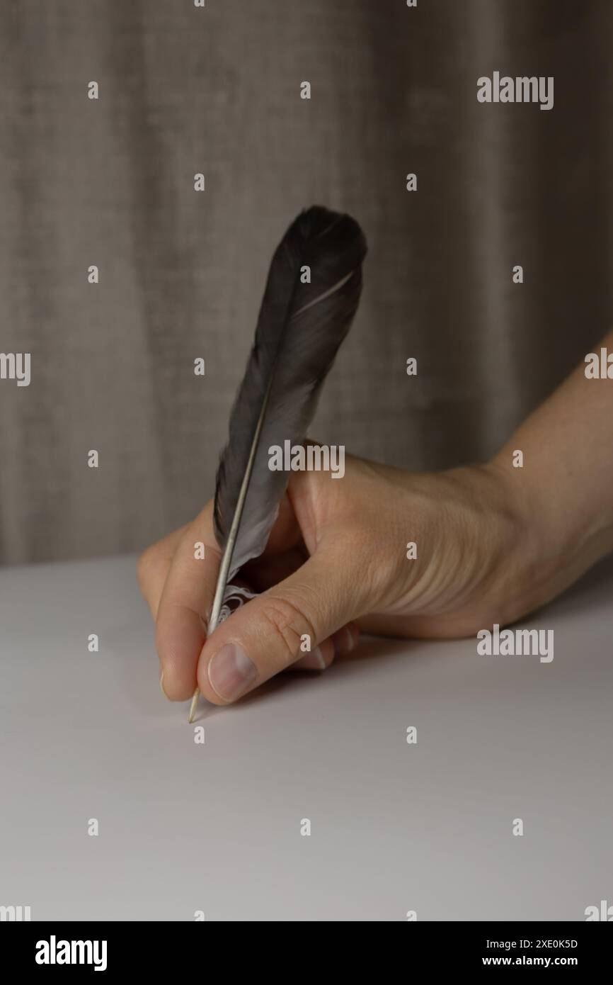 Hand holding quill pen isolated on the white background Stock Photo - Alamy