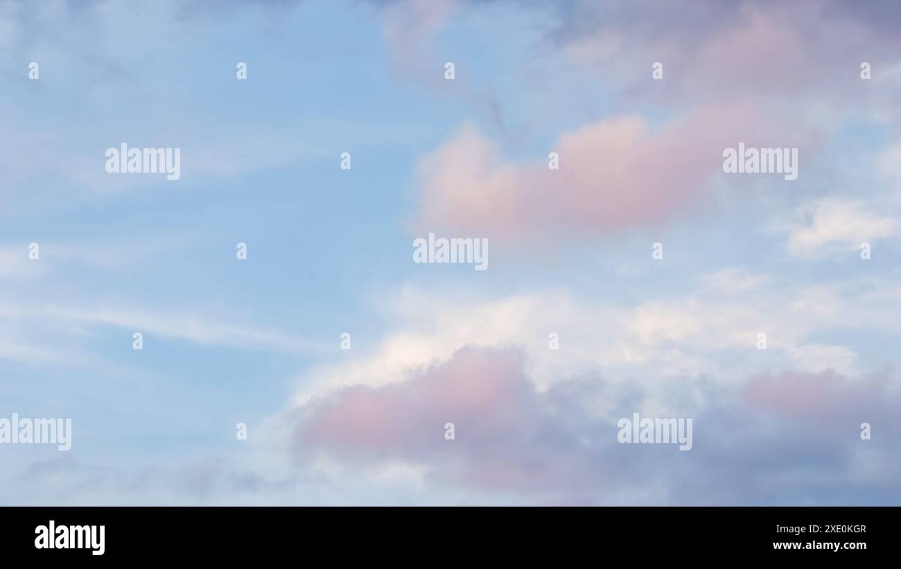 Blue sky background with pale pink clouds at sunset Stock Photo - Alamy