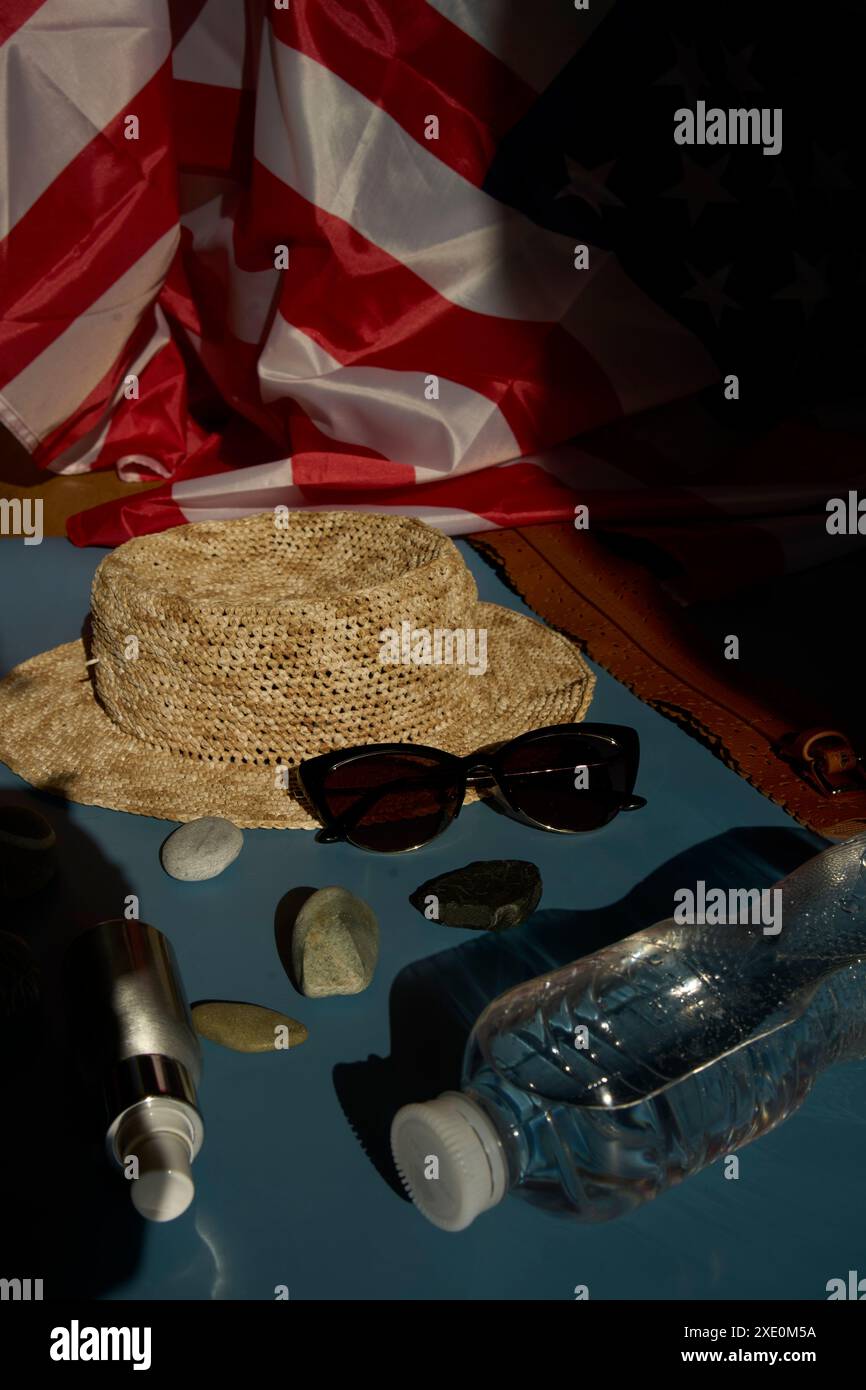 straw hat, sunglasses, bottle of water, sunscreen spray, american flag ...
