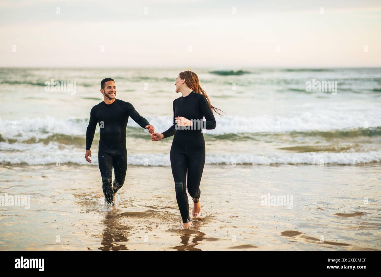Couple running towards ocean hi-res stock photography and images - Alamy