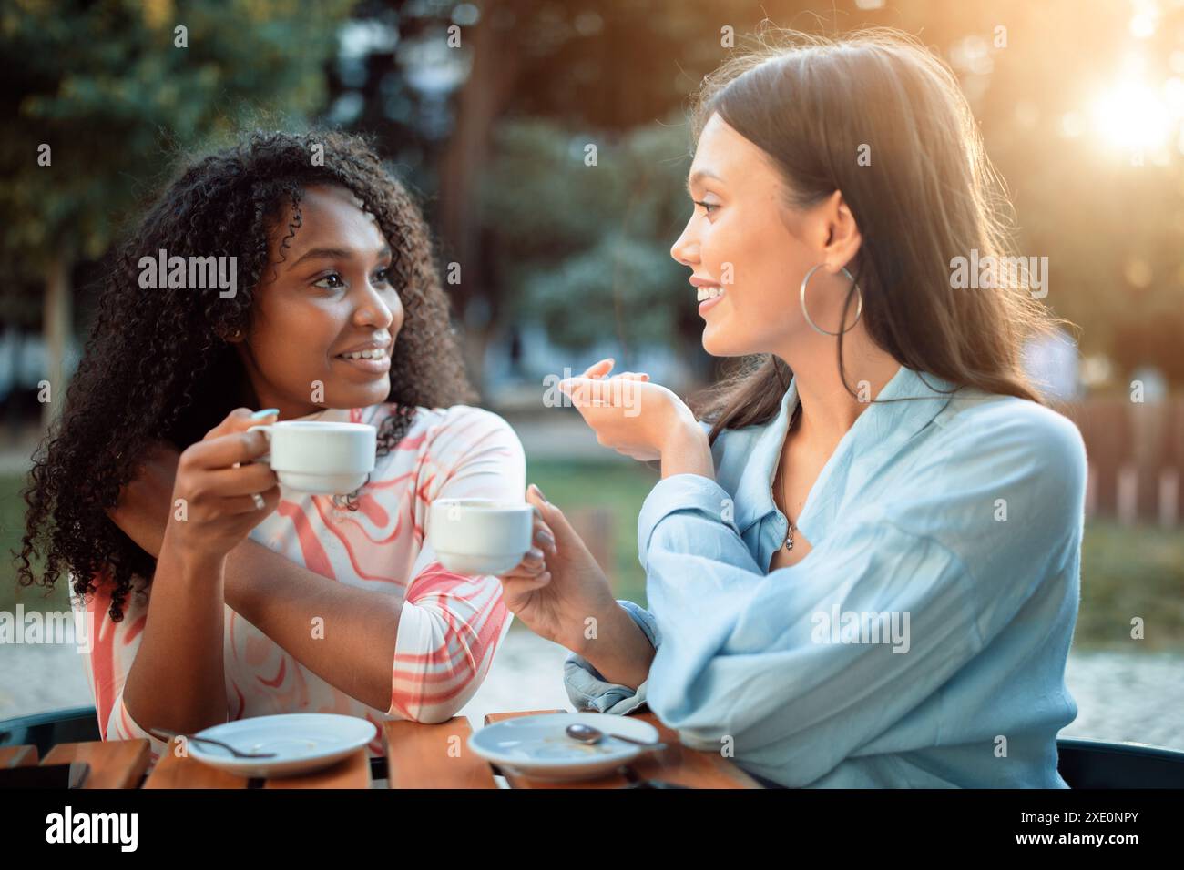Two Women Enjoying Coffee Together on a Sunny Afternoon Stock Photo - Alamy