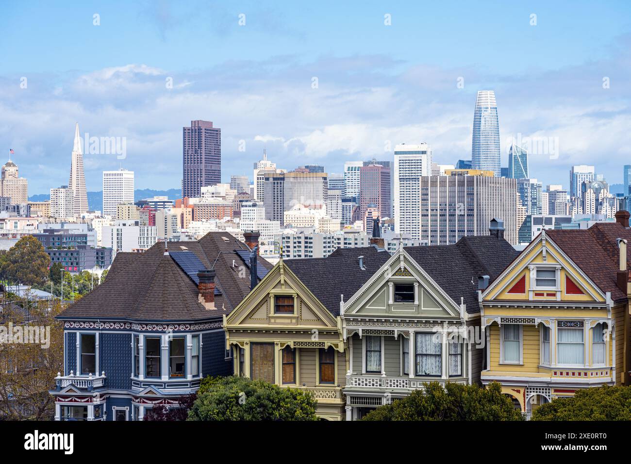 Old victorian houses in San Francisco with the downtown skyline in the ...