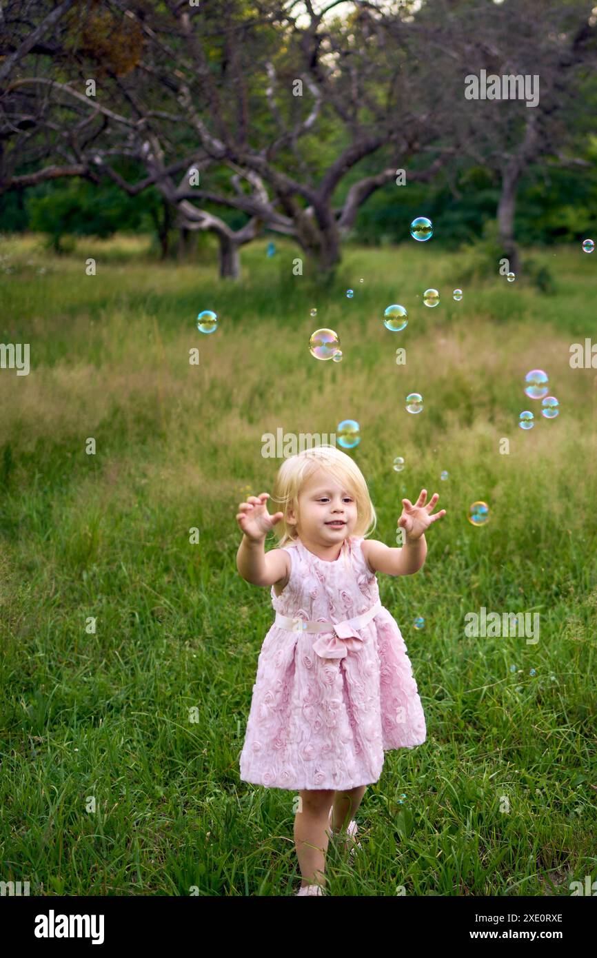 child and toddler, sisters, catching bubbles in the garden Stock Photo ...