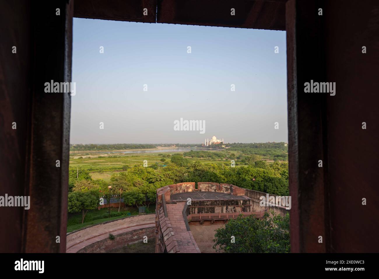 Distant daytime view of the Taj Mahal taken through an open window in ...