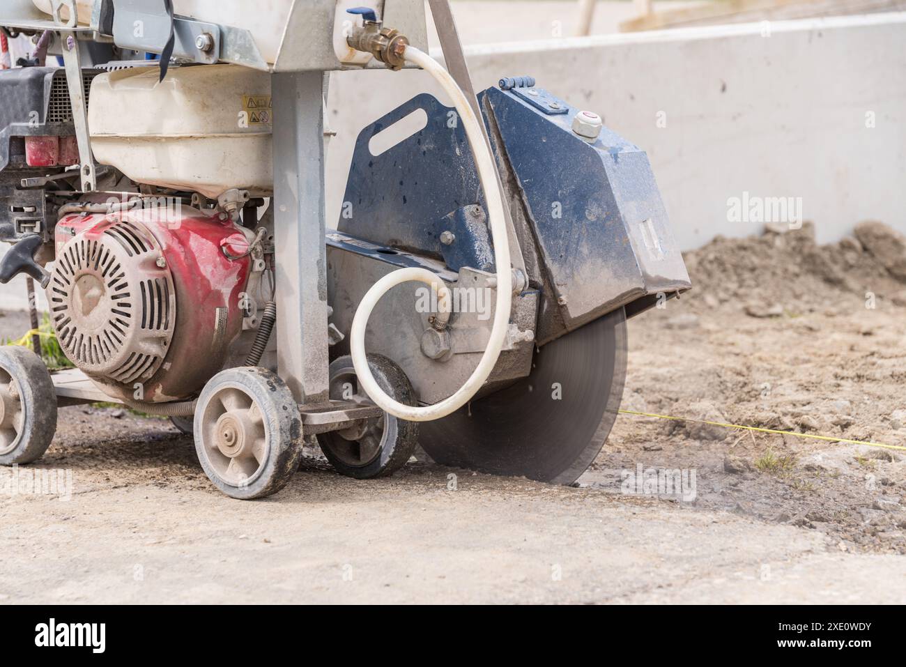 Construction worker works with asphalt cutting machine on construction ...