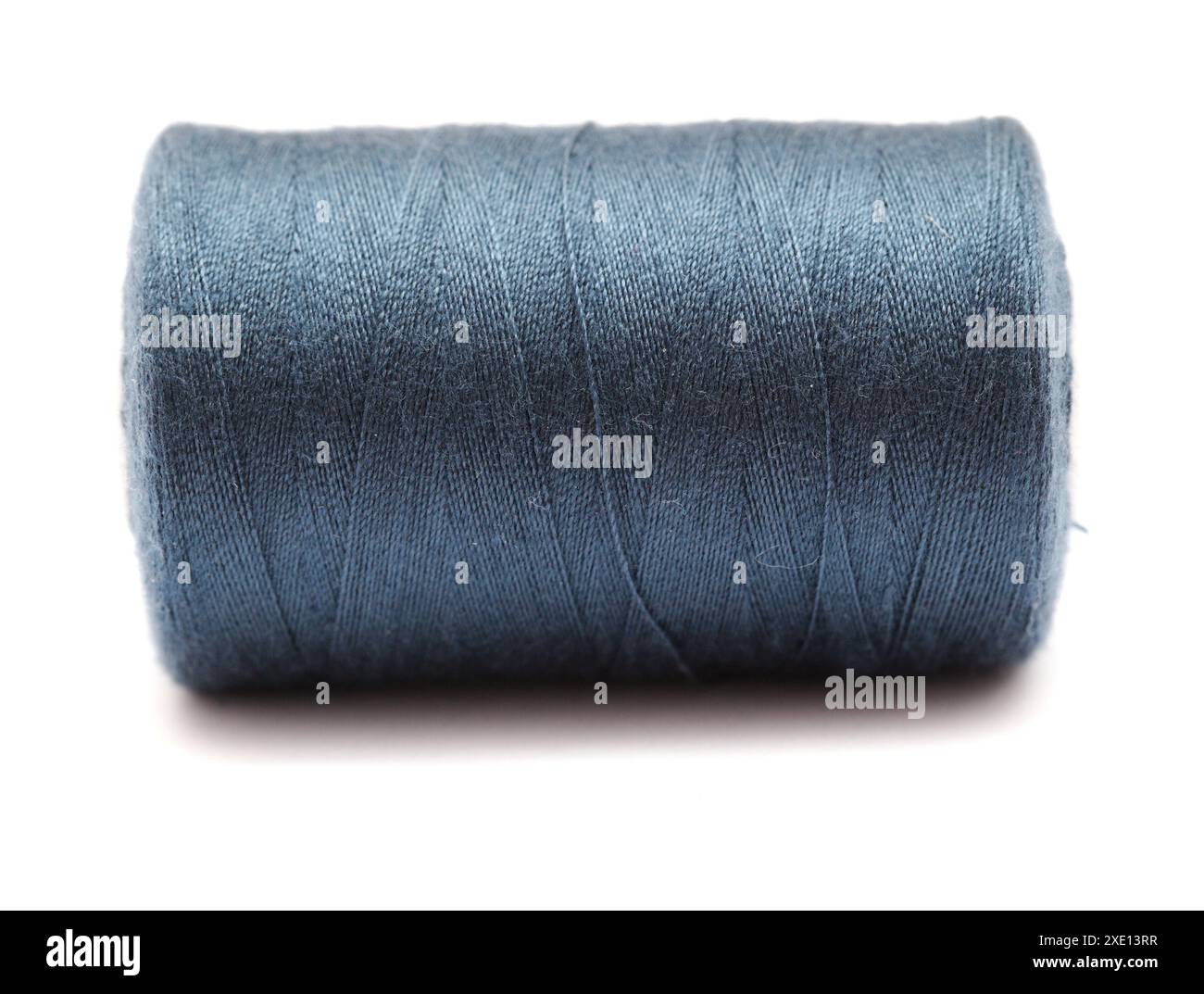 Full cross-wound spool of thin sewing tread isolated on white ...