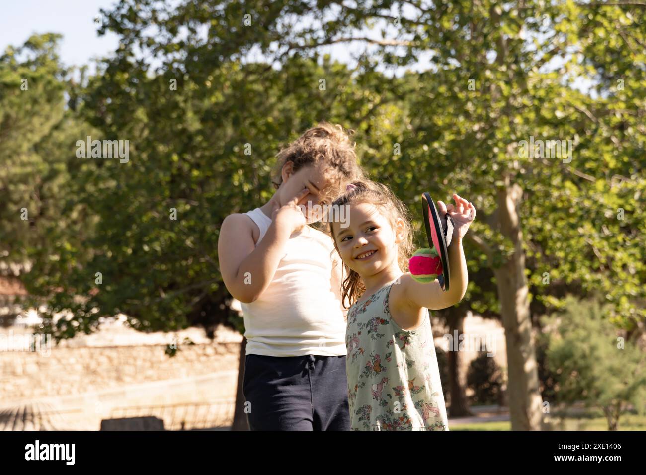 Big brother and little sister smile with mischievous gestures, enjoying ...