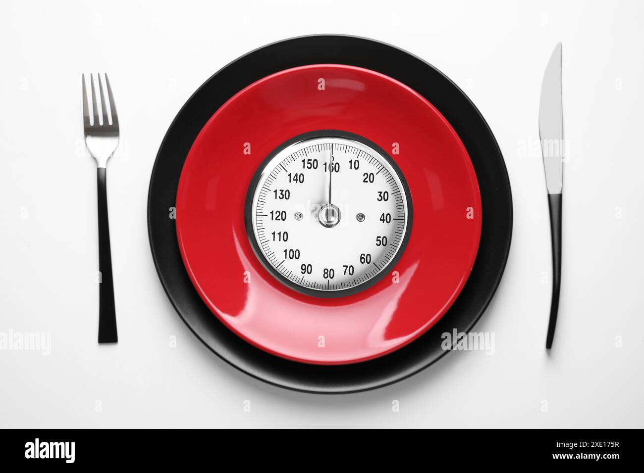 Plates with analog weighing scale display and cutlery isolated on white ...