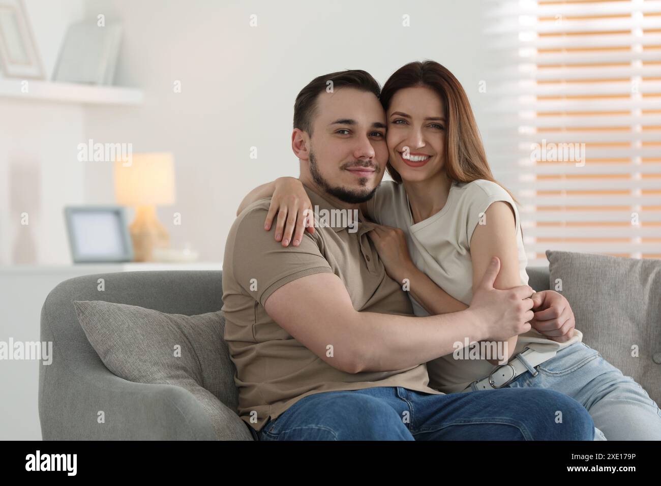 Cute couple hugging on sofa at home Stock Photo - Alamy