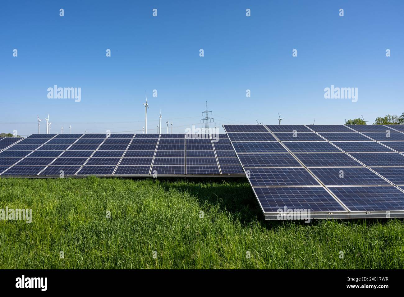 Solar plant with power lines and wind turbines in the back seen in ...