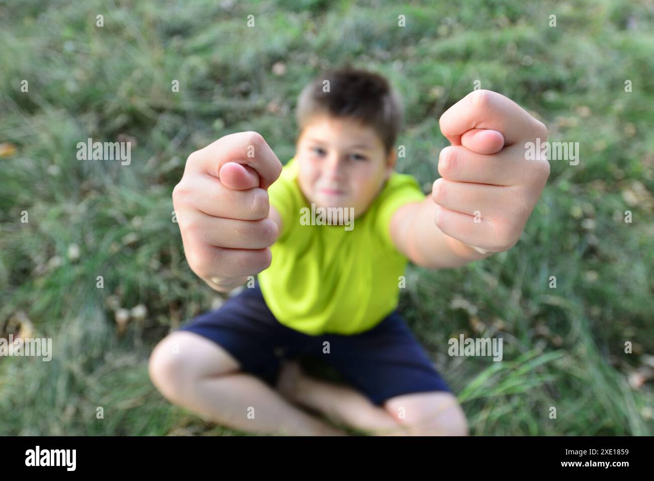 Teen boy shows the hand fig gesture on two hands Stock Photo - Alamy