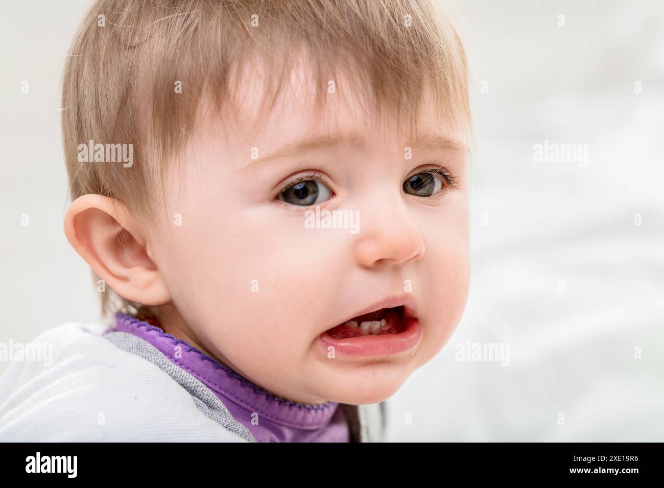 Sweet baby girl proudly showing her emerging teeth with a funny face ...