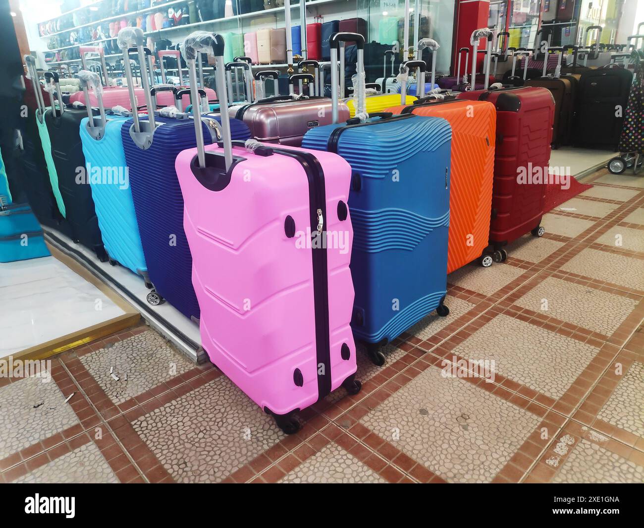 many new multi-colored large plastic suitcases on wheels. Concept of ...