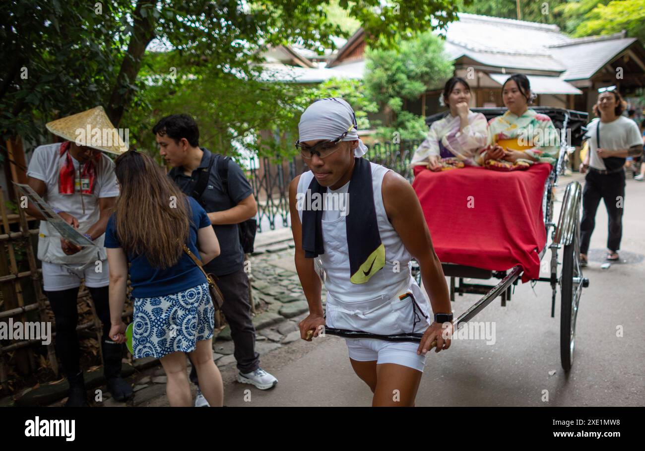 Tokyo, Japan. 25th June, 2024. A rickshaw rider pulls the Jinrikisha ...