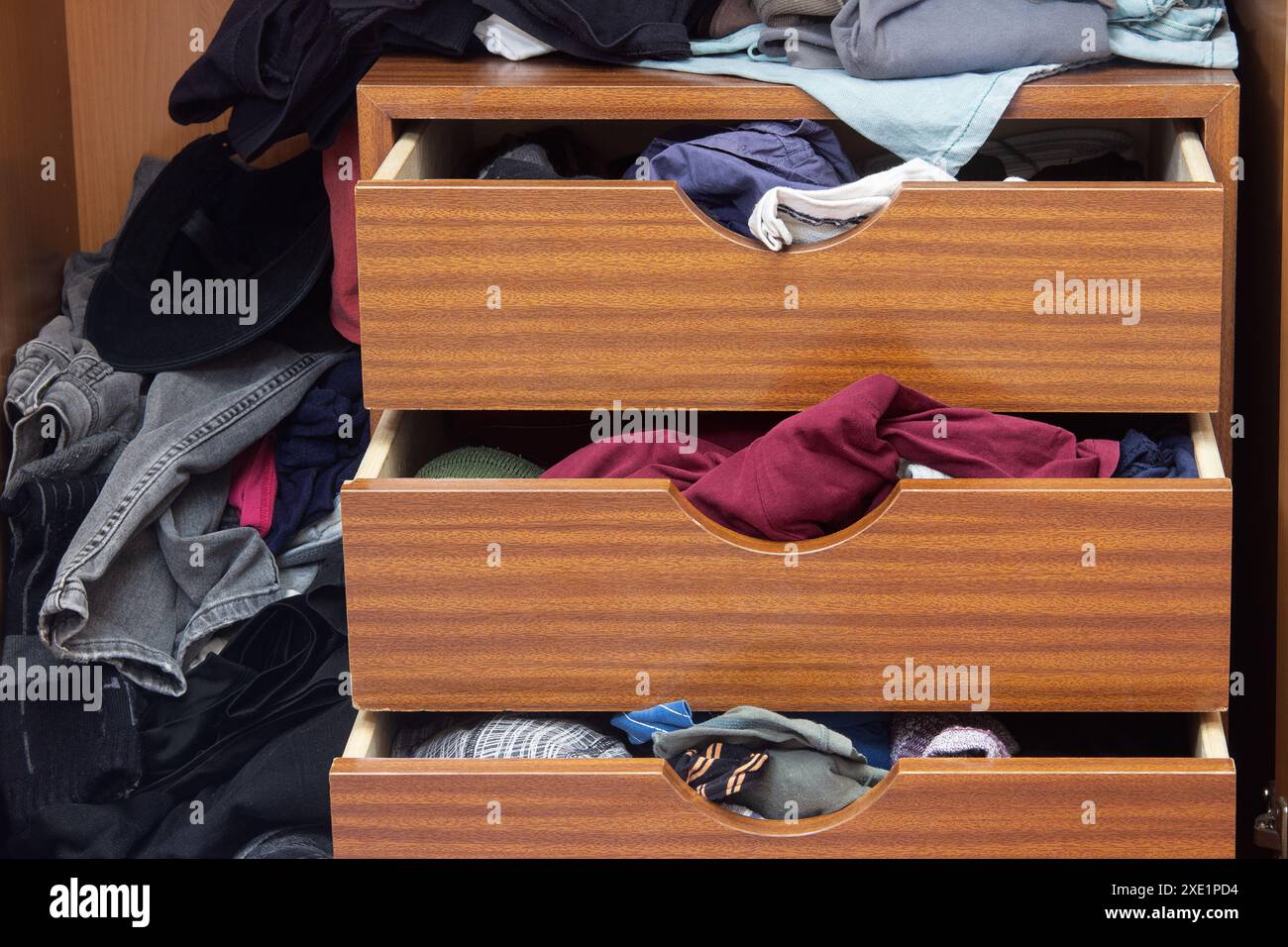 Open wooden dresser with overflowing drawers showcasing a mix of ...