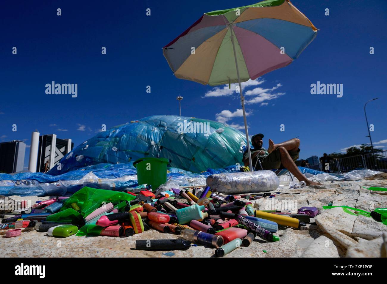Environmental activist Mundano performs as a tourist on a beach covered ...