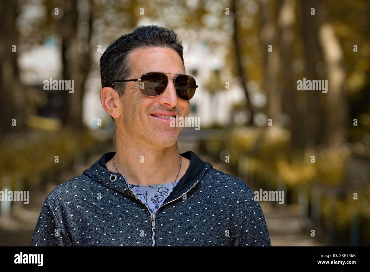 Mediterranean man in casual sports clothing and sunglasses, smiling ...