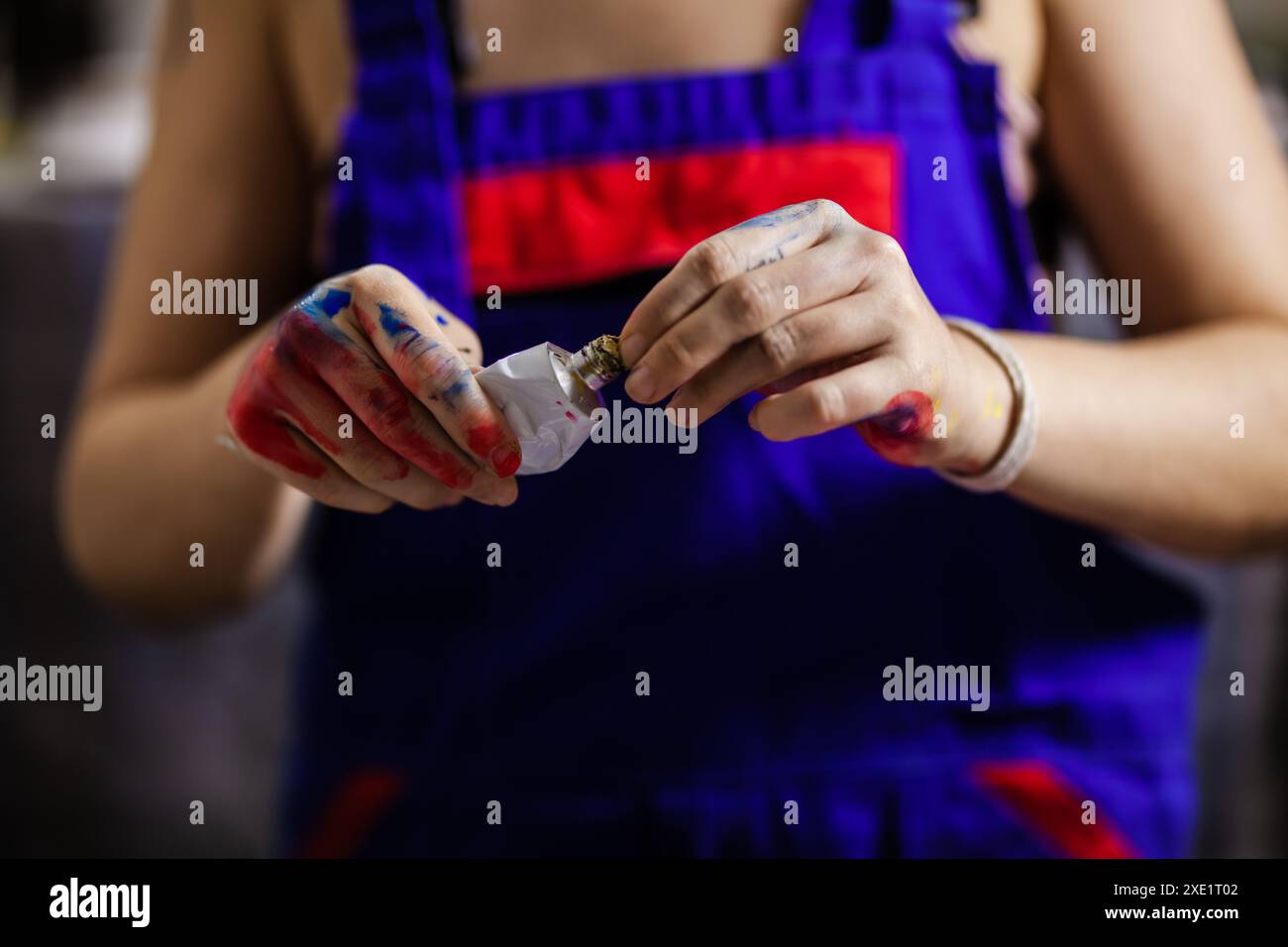 Close-up view of a female artist's hands, covered in multi-colored ...