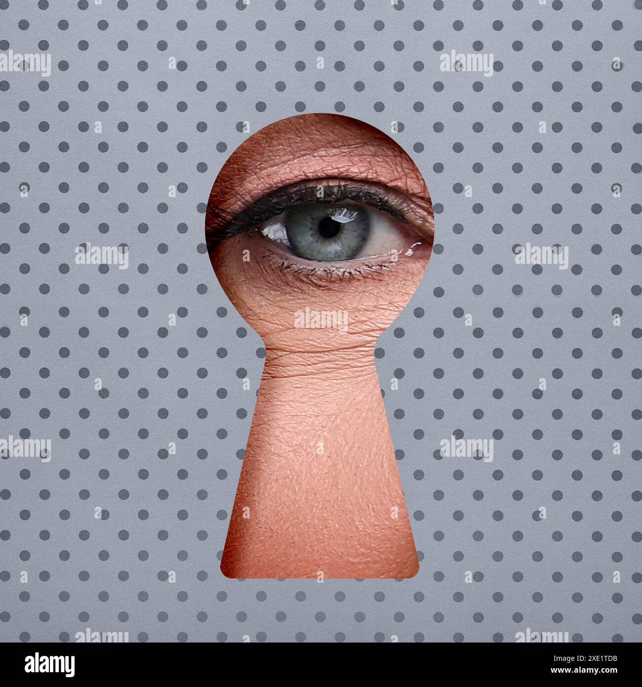 Woman looking through keyhole in grey dotted surface Stock Photo - Alamy