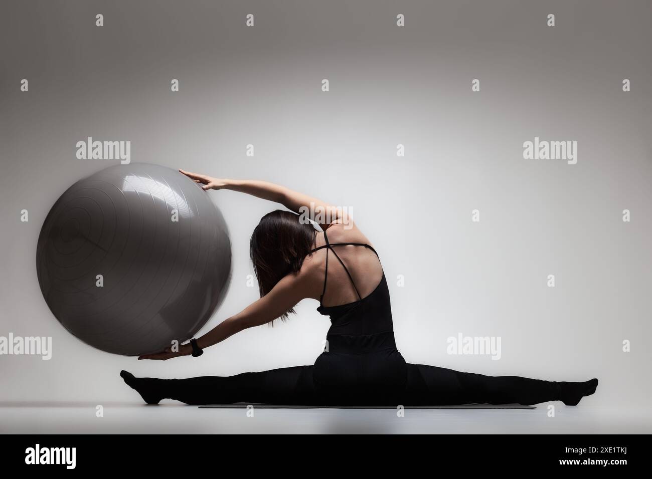 A young woman exhibits graceful flexibility and strength performing a ...