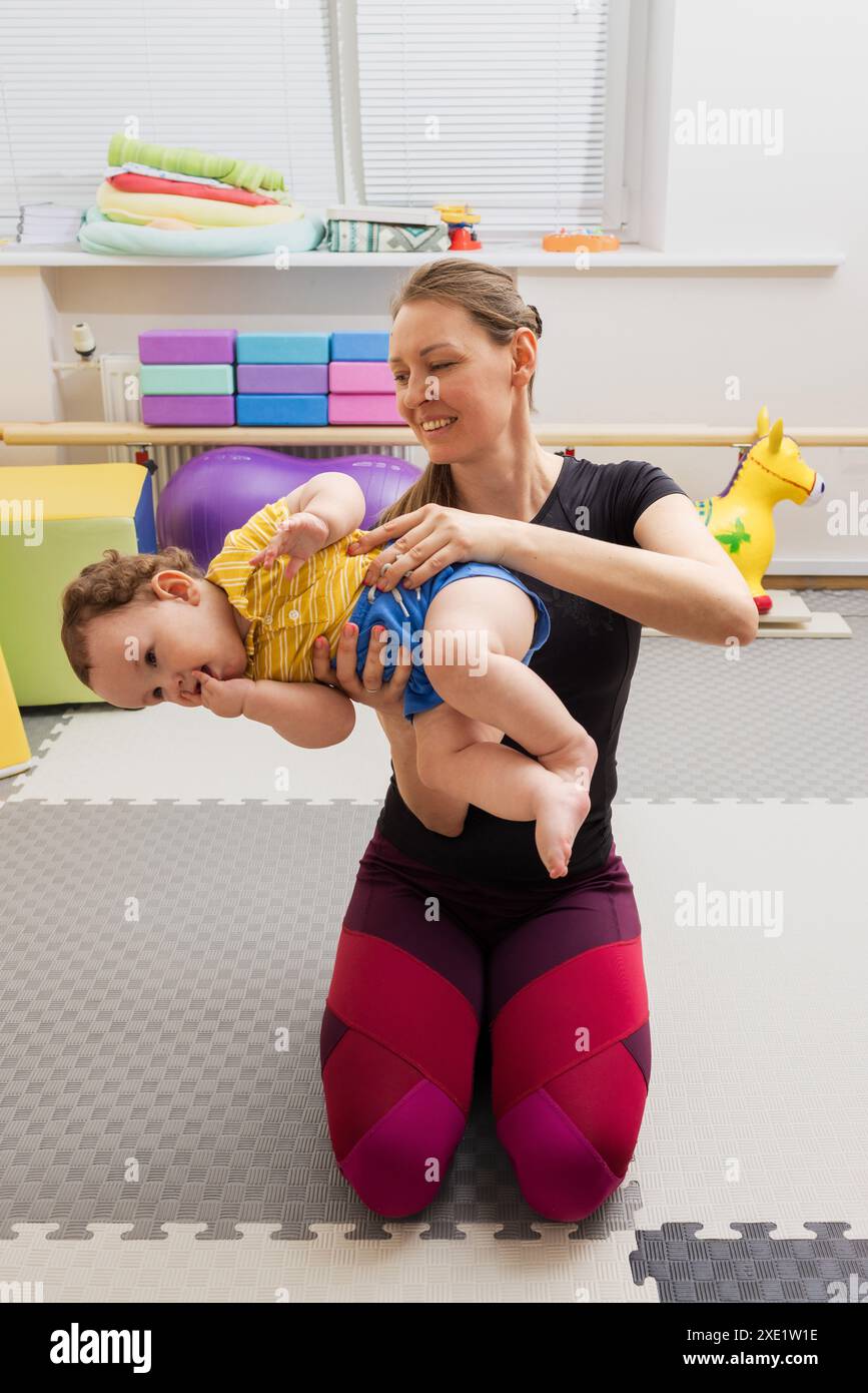 Physiotherapist assisting a young child with neurodevelopmental ...