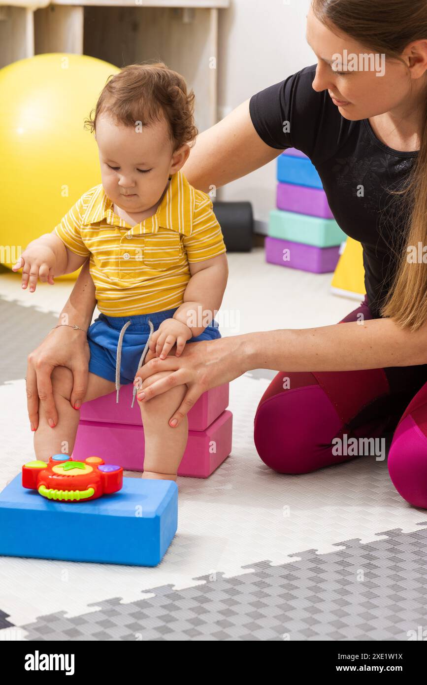 Birth trauma rehabilitation. Physical therapist assisting baby patient ...